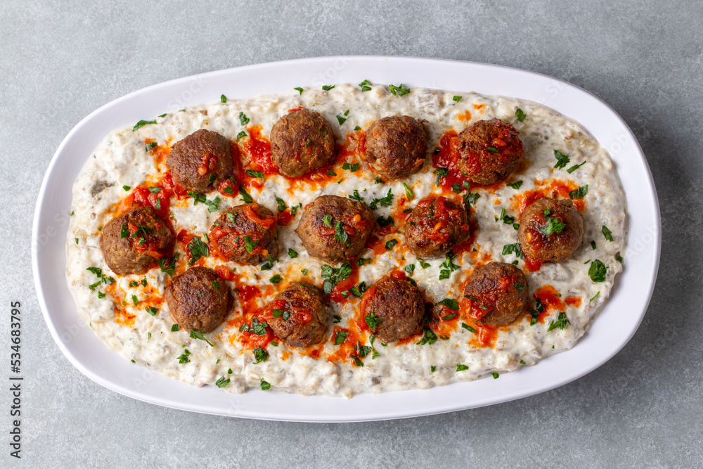 Traditional Turkish food; Meatballs on eggplant puree prepared with ...