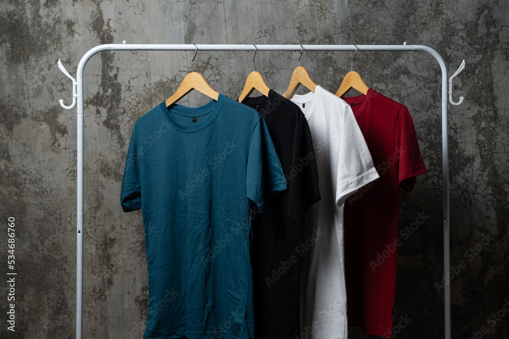 Plain t-shirts of various colors are hung on the clothes rack. Stock ...