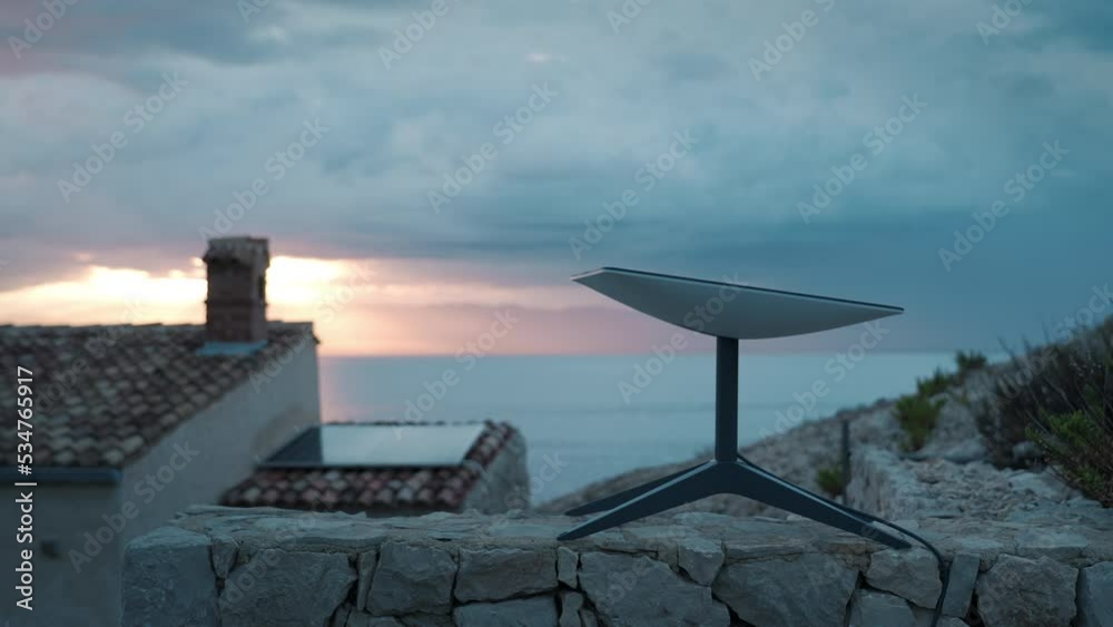 Close-up shot of moving Starlink satellite internet receiver on a fence ...