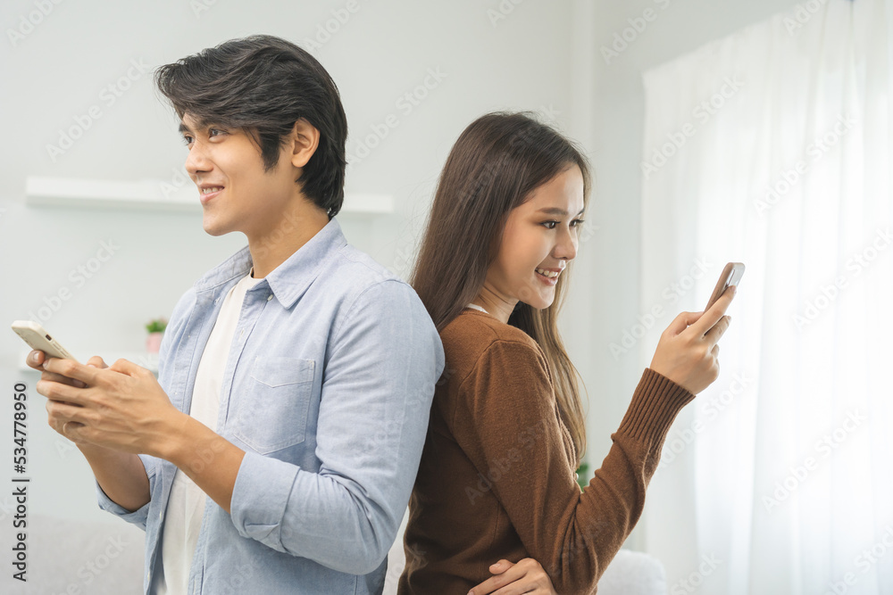 Foto de Infidelity, suspicion asian young couple love standing back to back, husband watching ...