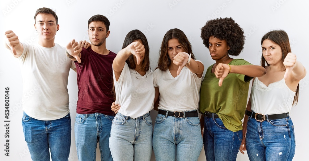 Group of young friends standing together over isolated background ...