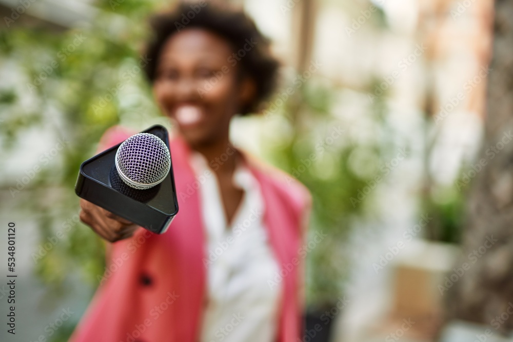 Young african american woman journalist pointing reporter microphone to ...