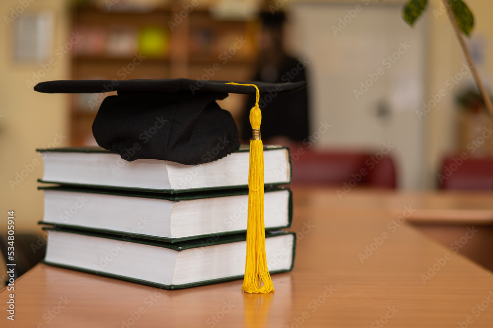 Graduation cap on a stack of books in the library. Stock-Foto | Adobe Stock