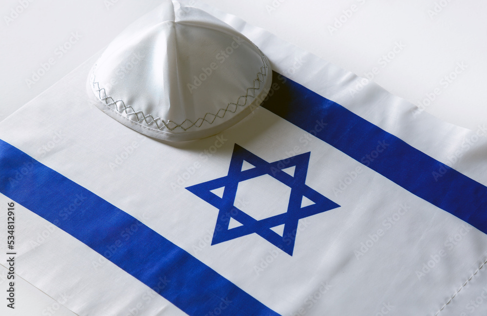 Kippah (religious hat) with the flag of Israel in the background. Still ...
