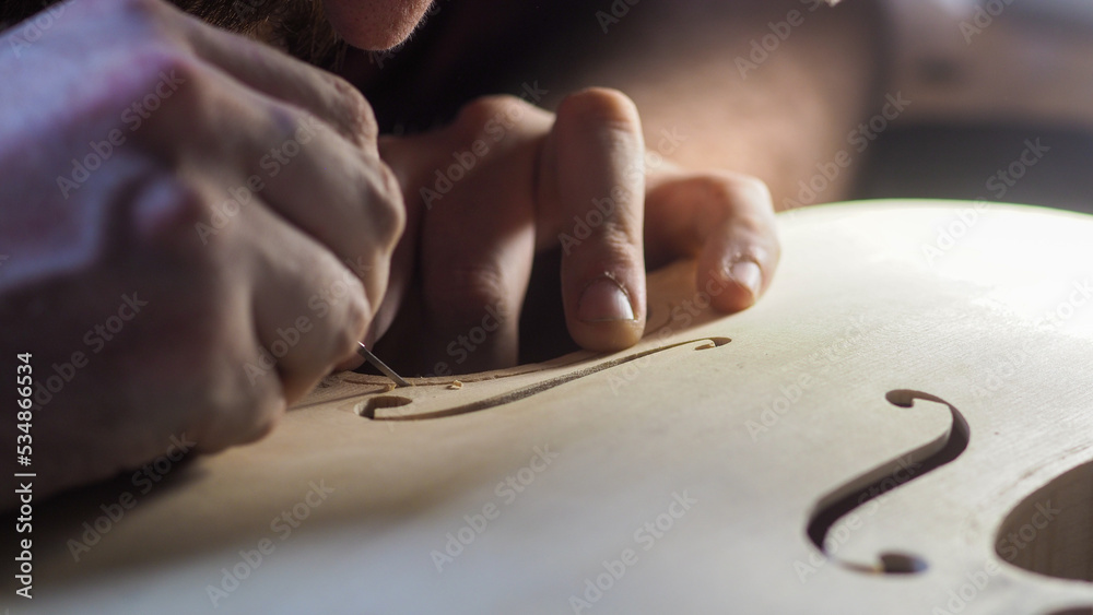 luthier violin maker working on the f holes on a raw new violin Stock ...
