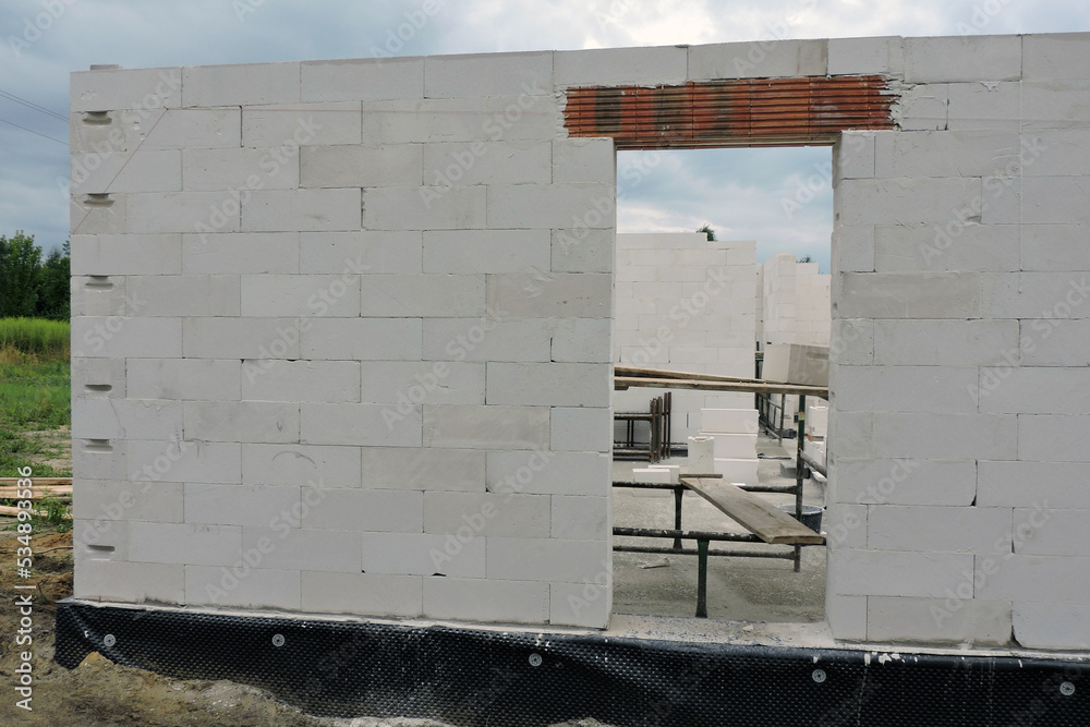 A house under construction, walls made of acc blocks, a rough door ...
