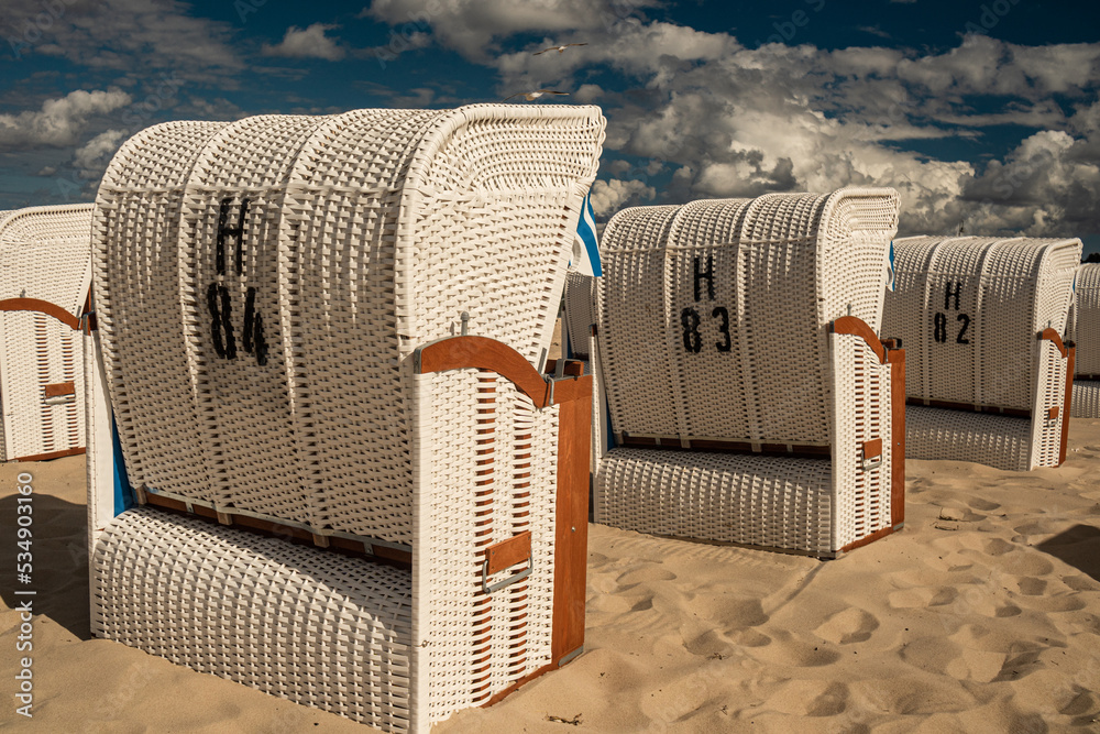 Wicker roofed beach chairs at the sand beach. Strandkorb at north ...