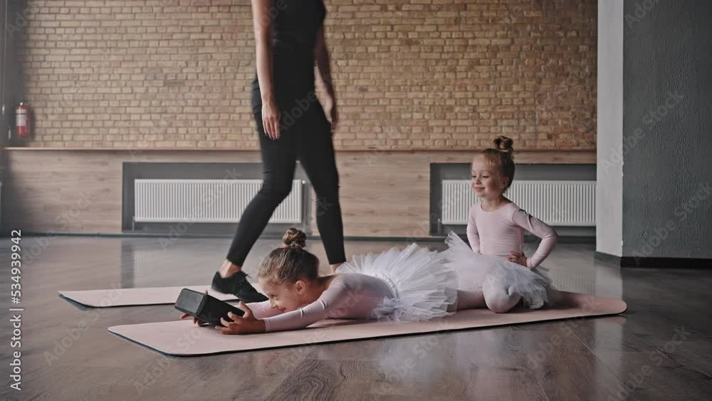 Girl stretches body on mat using weight for ballet posture vídeo de ...