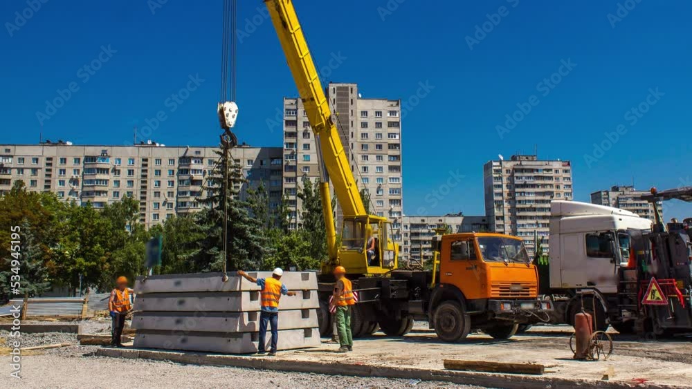 Unloading concrete plates by crane at road construction site timelapse ...