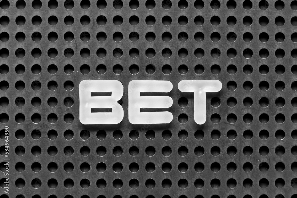 White alphabet letter in word bet on black pegboard background Stock ...