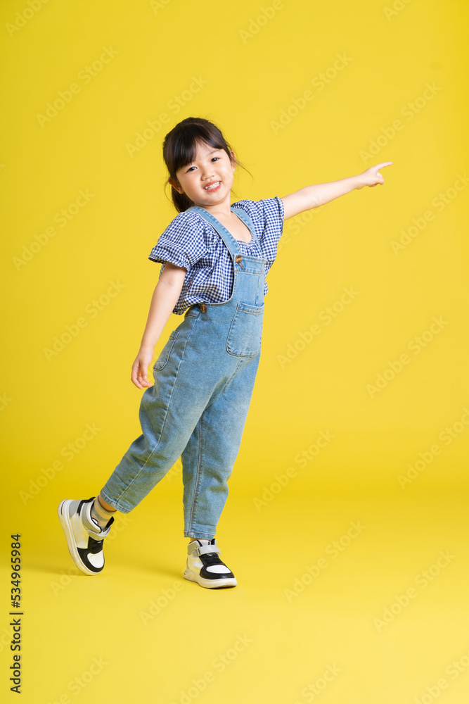 full body image of beautiful asian baby girl on yellow background Stock ...