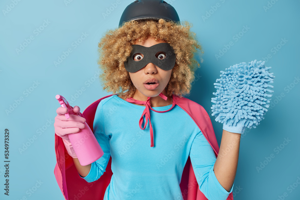 Waist up shot of amazed scared curly female model dressed in superhero ...