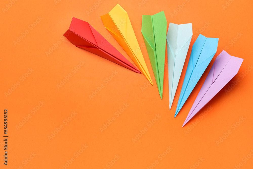 Colorful paper planes on orange background Stock Photo | Adobe Stock