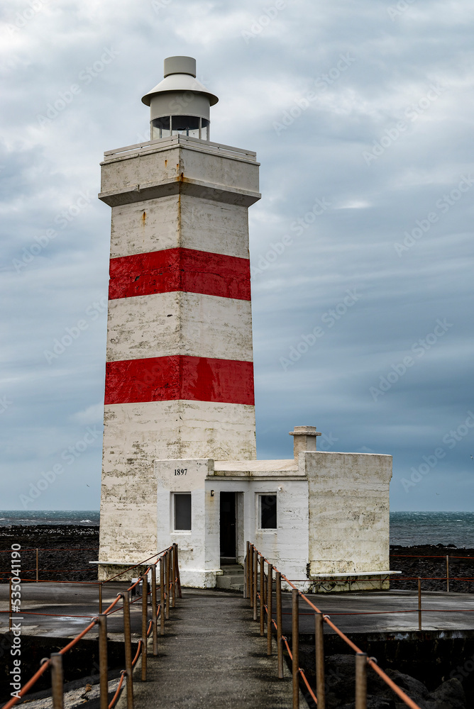 The old Garðskagi lighthouse in Garður under a cloudy sky, Reykjanes ...