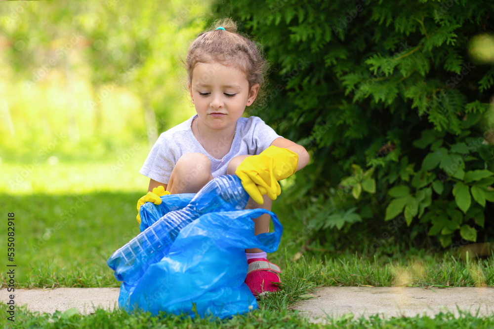 Girl collection plastic garbage in nature. kid picking up trash in park ...