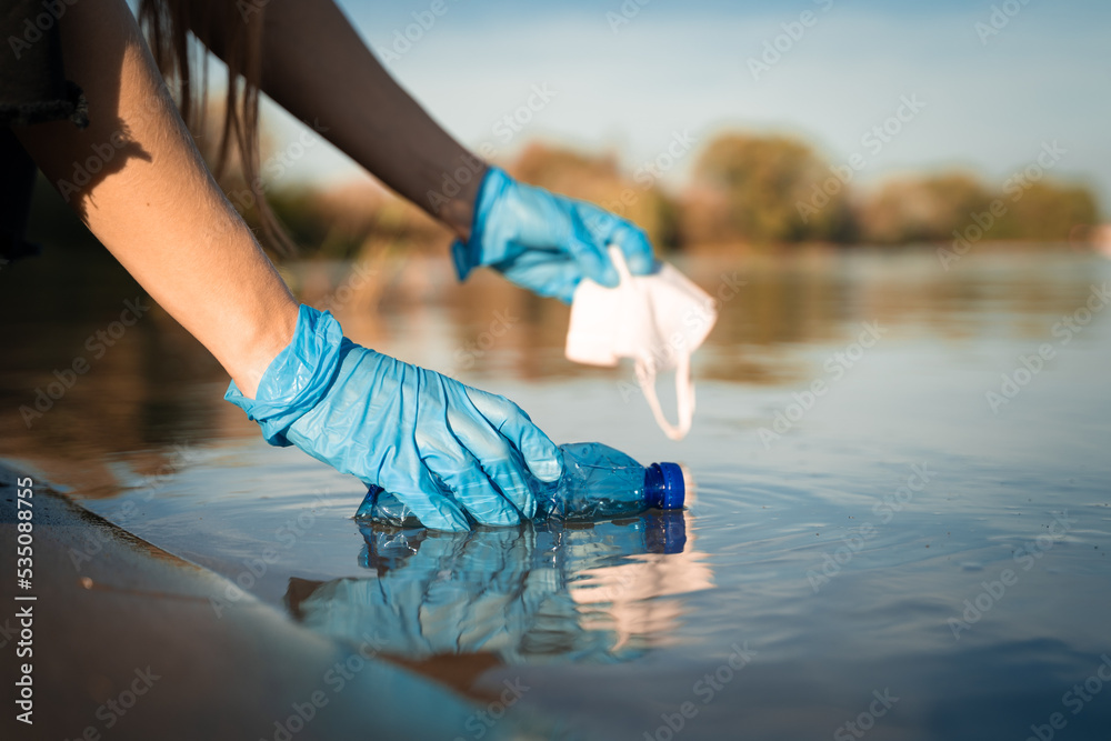 Hands collecting garbage and garbage from river, sea water, collecting ...