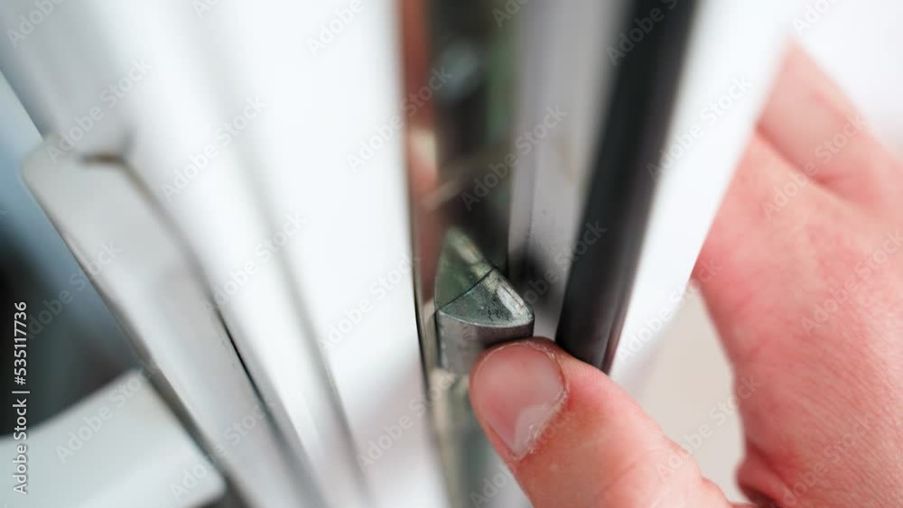 The finger checks the spring mechanism of the latch of the door lock of ...