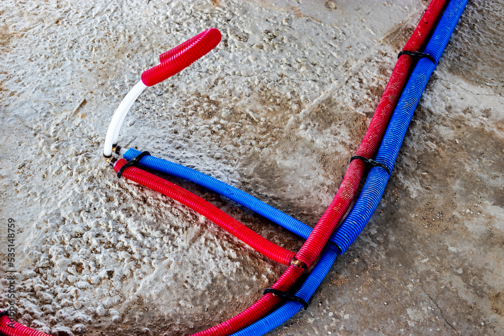 Water pipes corrugated in red and blue. Plumbing system in the floor ...