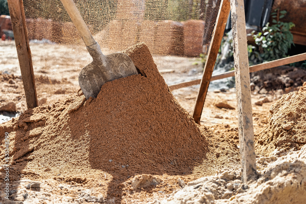 Sifting sand for mortar at the construction site. Purification of sand ...