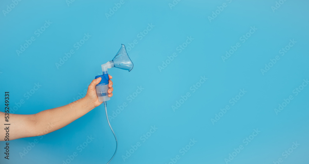 Medical inhaler in hand on a blue background , asthma disease treatment ...