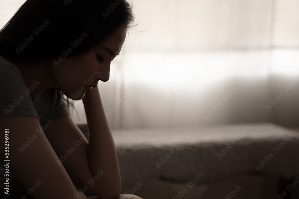 Depressed woman sitting alone on the bed with hands on head feel stress ...