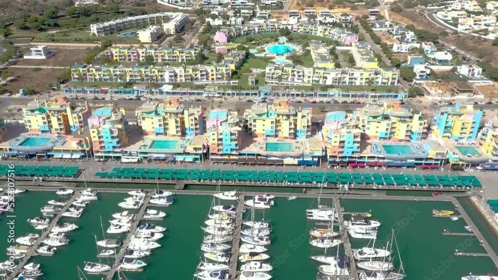Cinematic aerial view of luxury Albufeira harbour. Drone going backward ...
