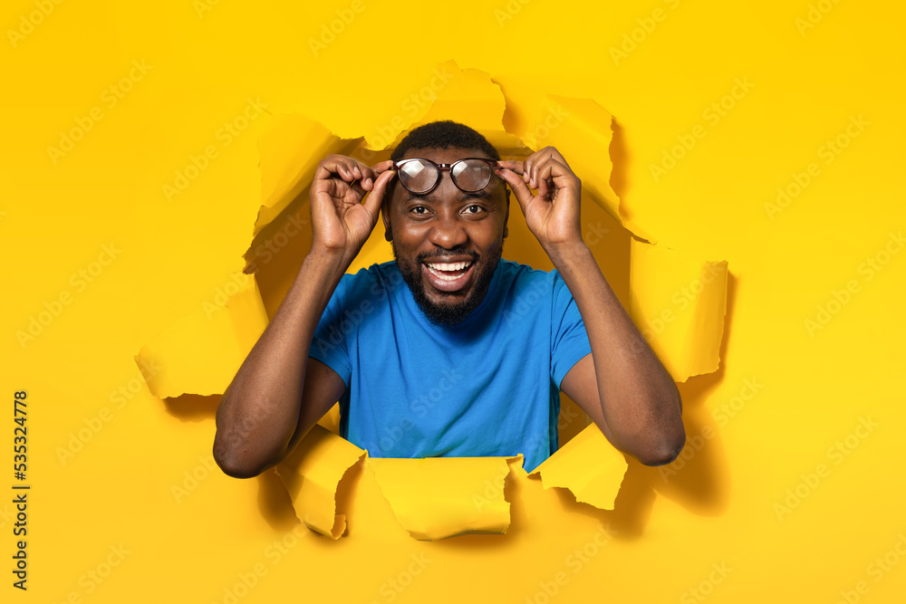Excited black man taking off eyeglasses and smiling at camera, standing ...