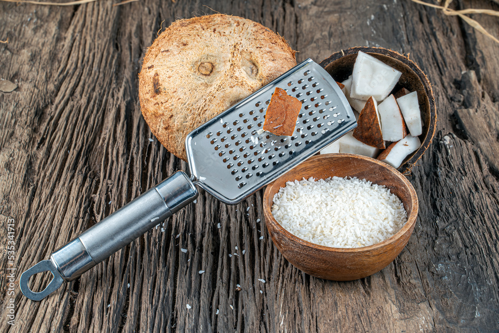 Whole,cut and grated coconut,fresh coconut slice is seen grating with a ...