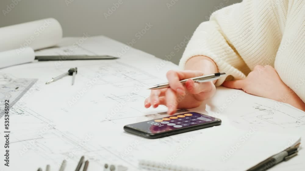 Architect designer counting on a calculator, drawing plan blueprint ...