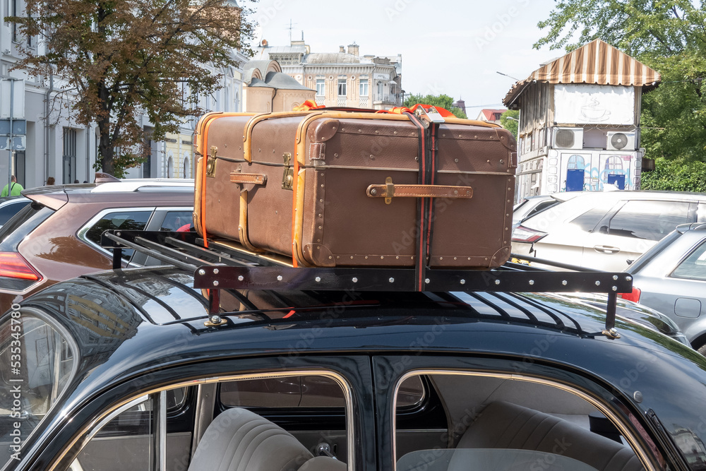 old vintage suitcases on top of the car, concept of travelling by car ...