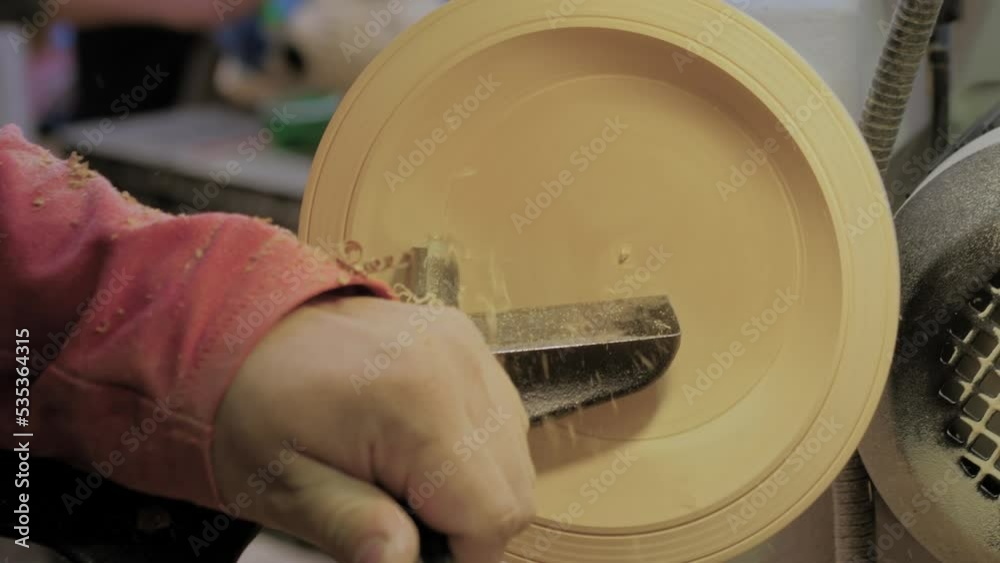Man carpenter using gouge for shaping piece of wood on turning lathe ...