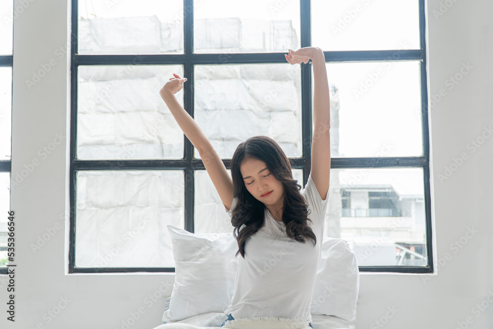 Healthy asian woman waking up relax muscles beside window early in ...