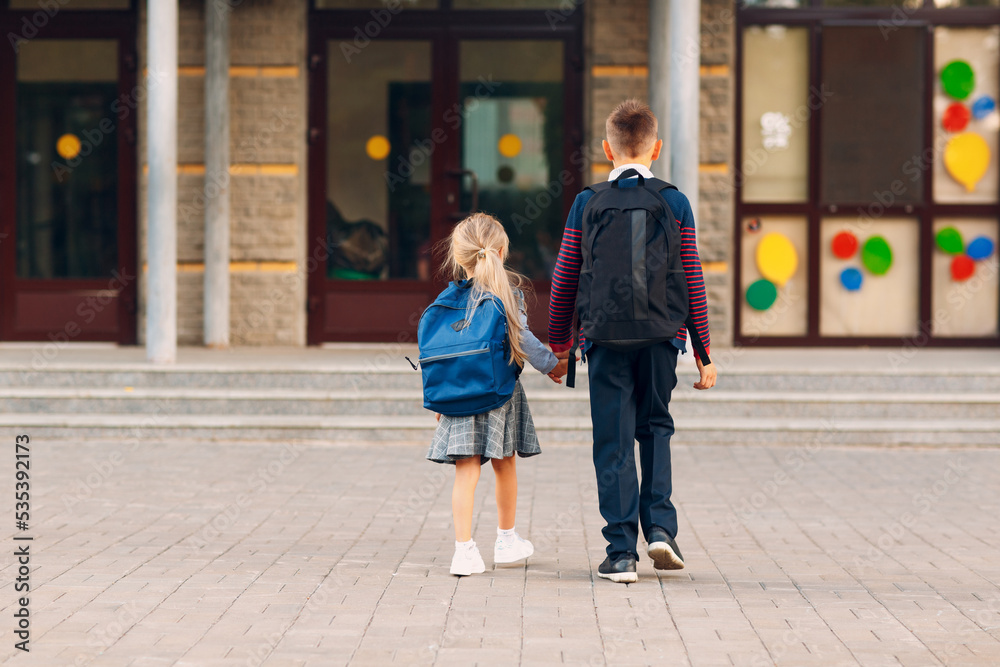 Back view of brother and sister holding hands walking to school Stock ...