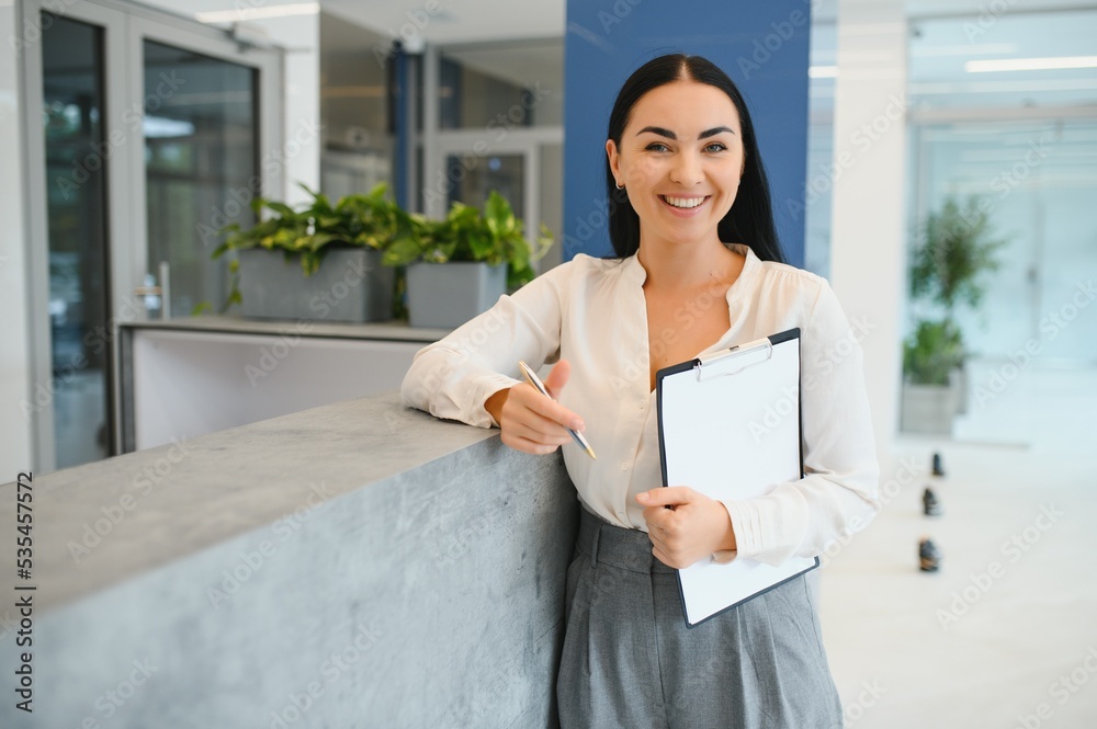 Portrait of beautiful receptionist near counter in hotel фотография ...