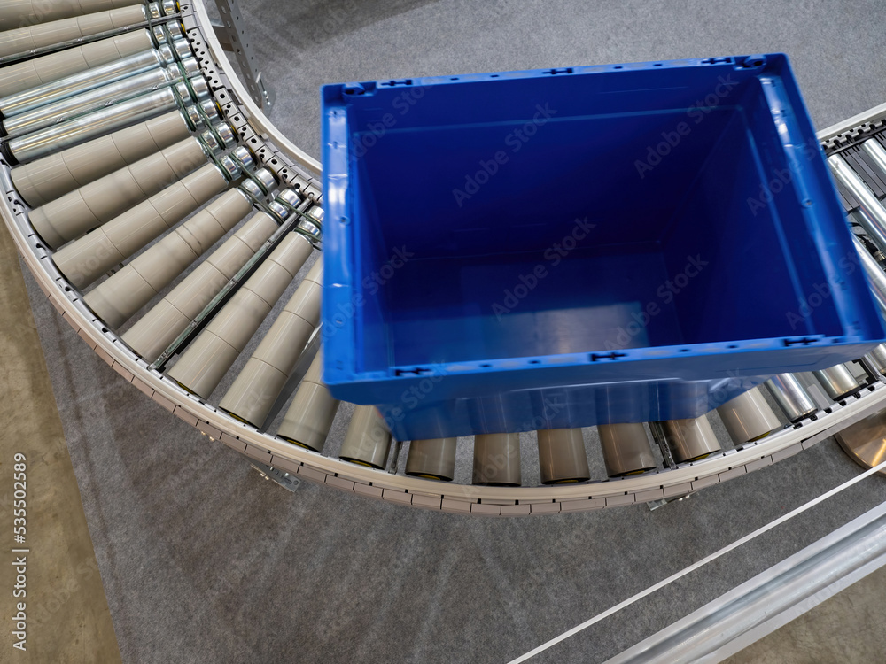 Conveyor with empty container. Plastic box moves along conveyor ...