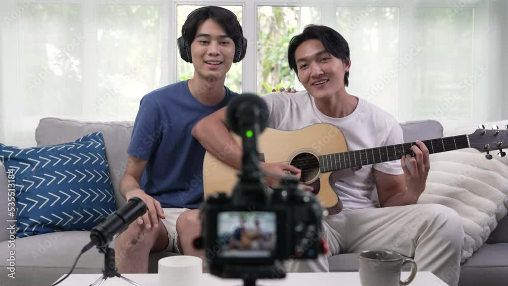 Young Asian gay couple blogger vlogger and online influencer recording ...