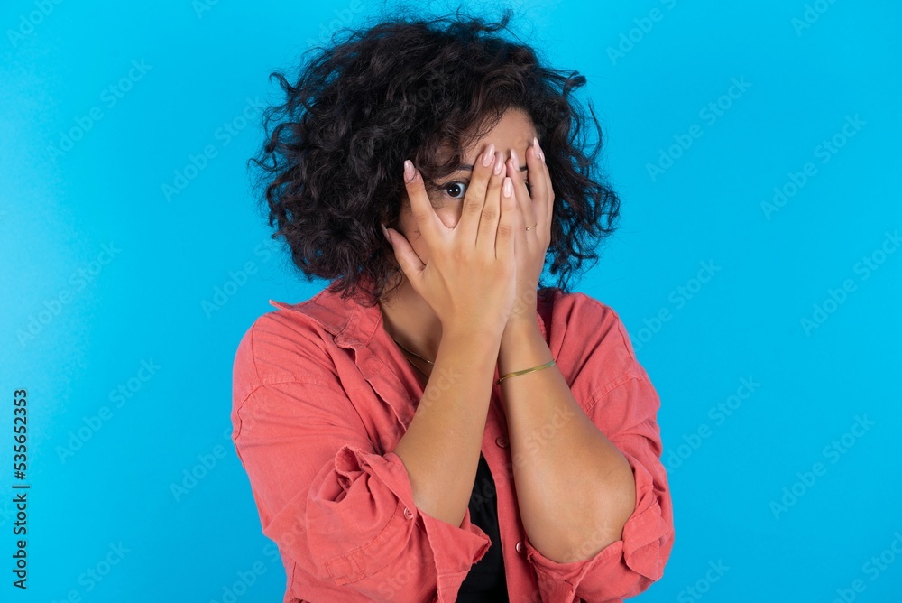young beautiful woman with curly short hair wearing red overshirt over ...