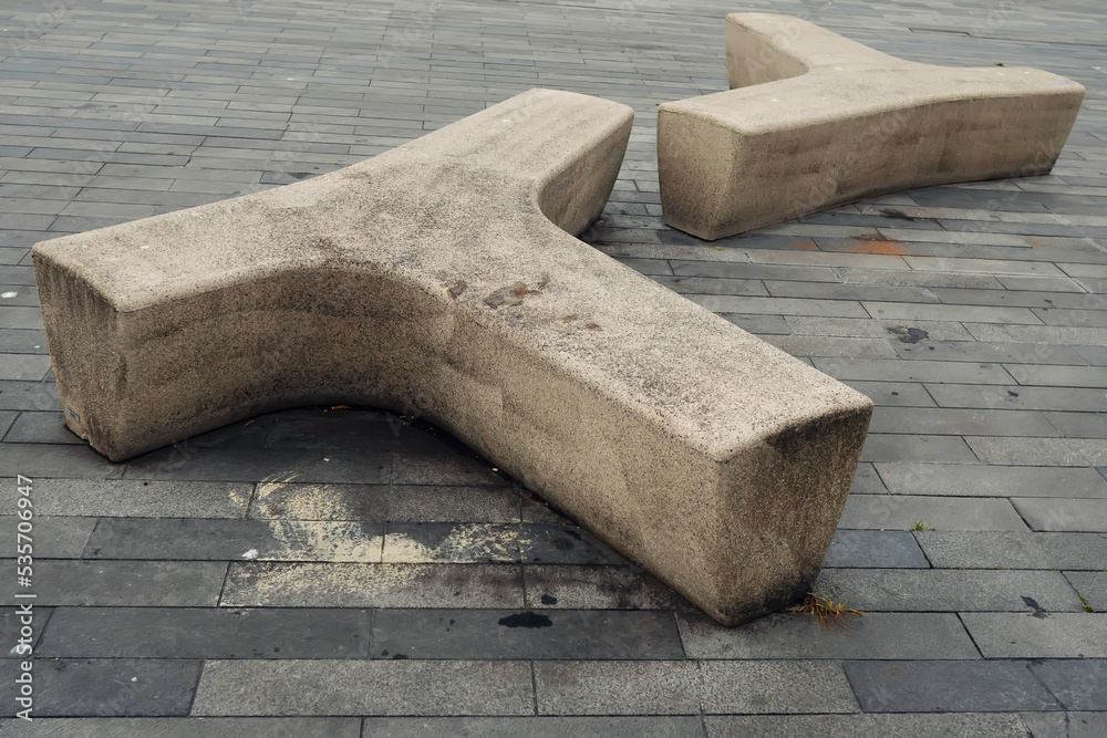 T shape dirty concrete seat in a square. Sitting area in a public space ...