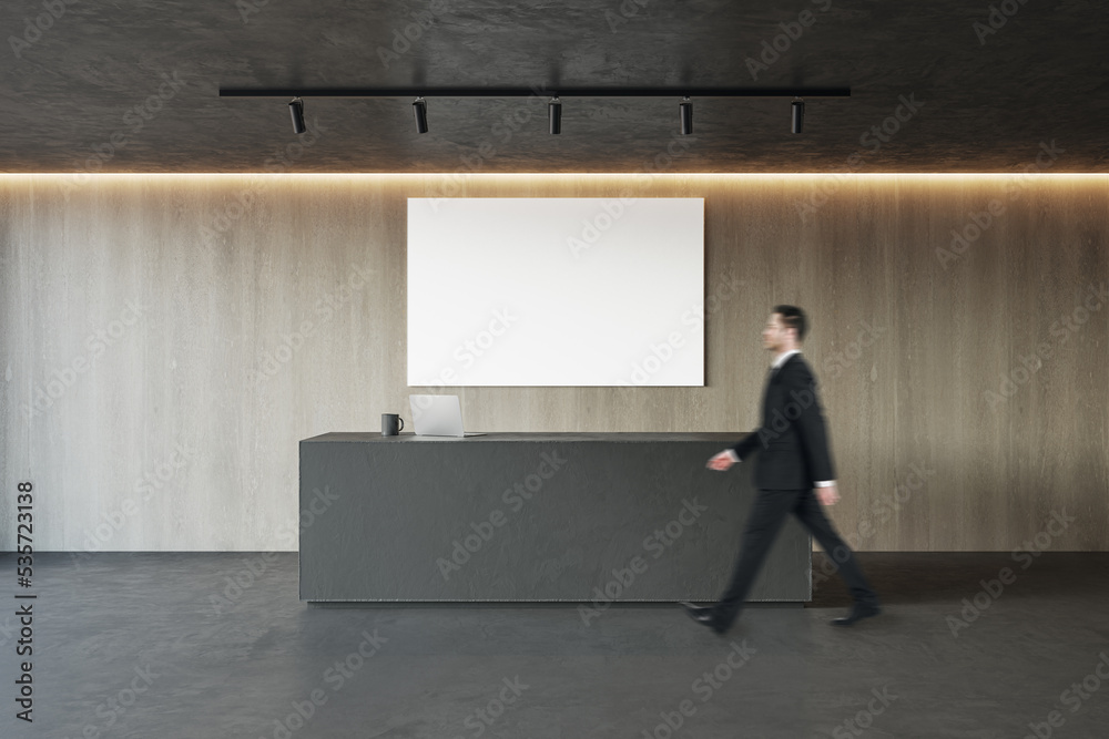 Side view of young businessman walking in modern concrete and wooden ...