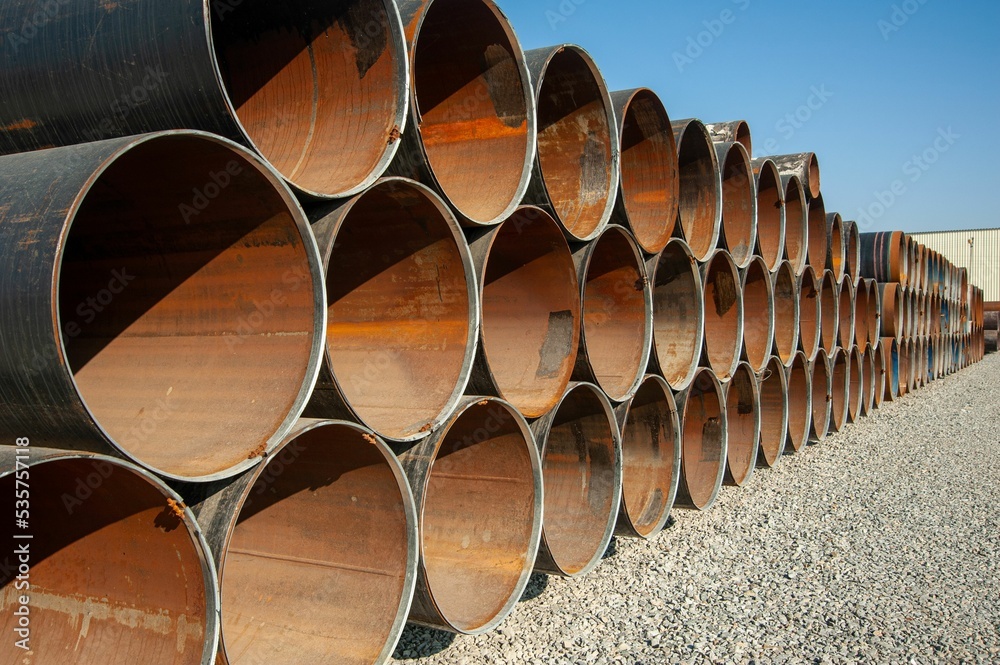 Line of oilfield large streel pipes in industrial construction area ...