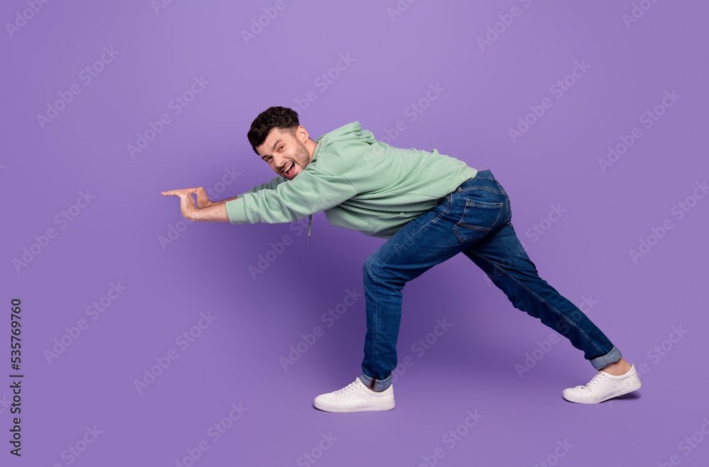 Full size photo of handsome young man pushing heavy empty space dressed ...