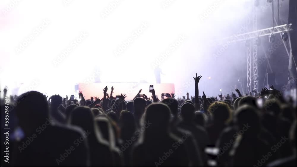 Flashing neon lights on concert stage in front of fans cheering and ...