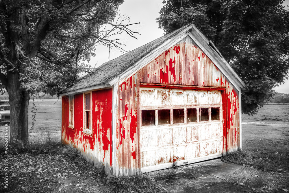Selective Red Color in a Black and White photo of an old garage in need of repair. Paint peeling ...