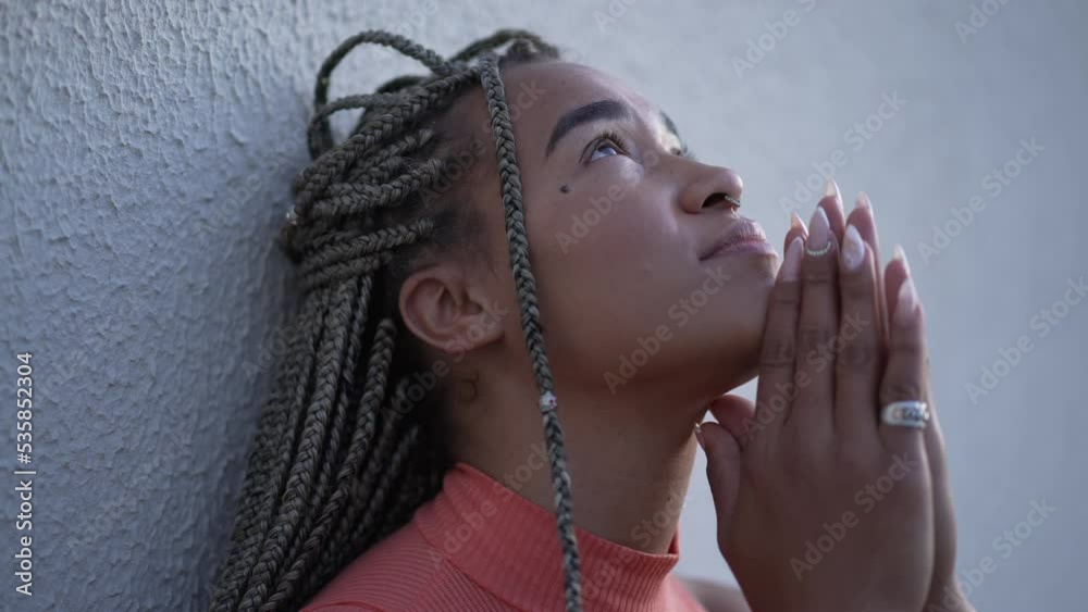 One spiritual young black woman praying to God pleading help and ...
