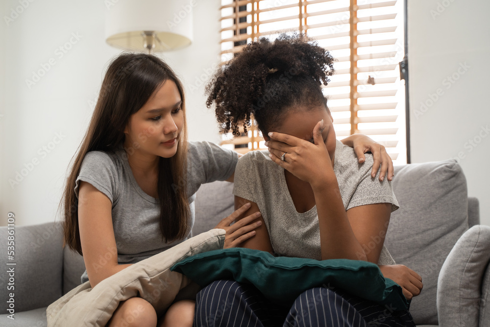 Depressed sad crying woman sitting with friend to support and calm down ...