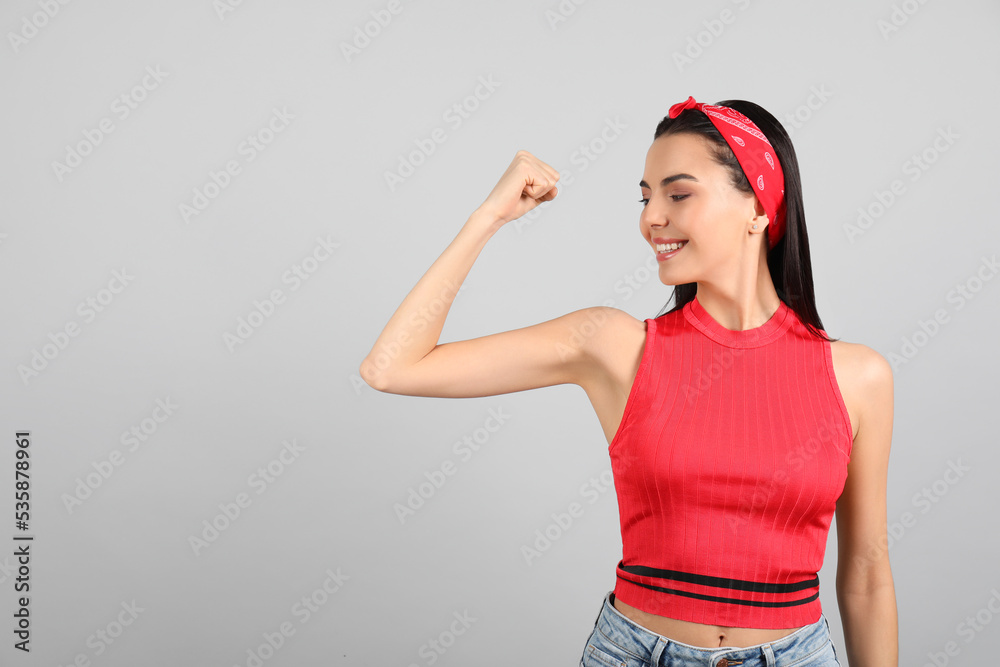 Strong woman as symbol of girl power on light grey background, space ...