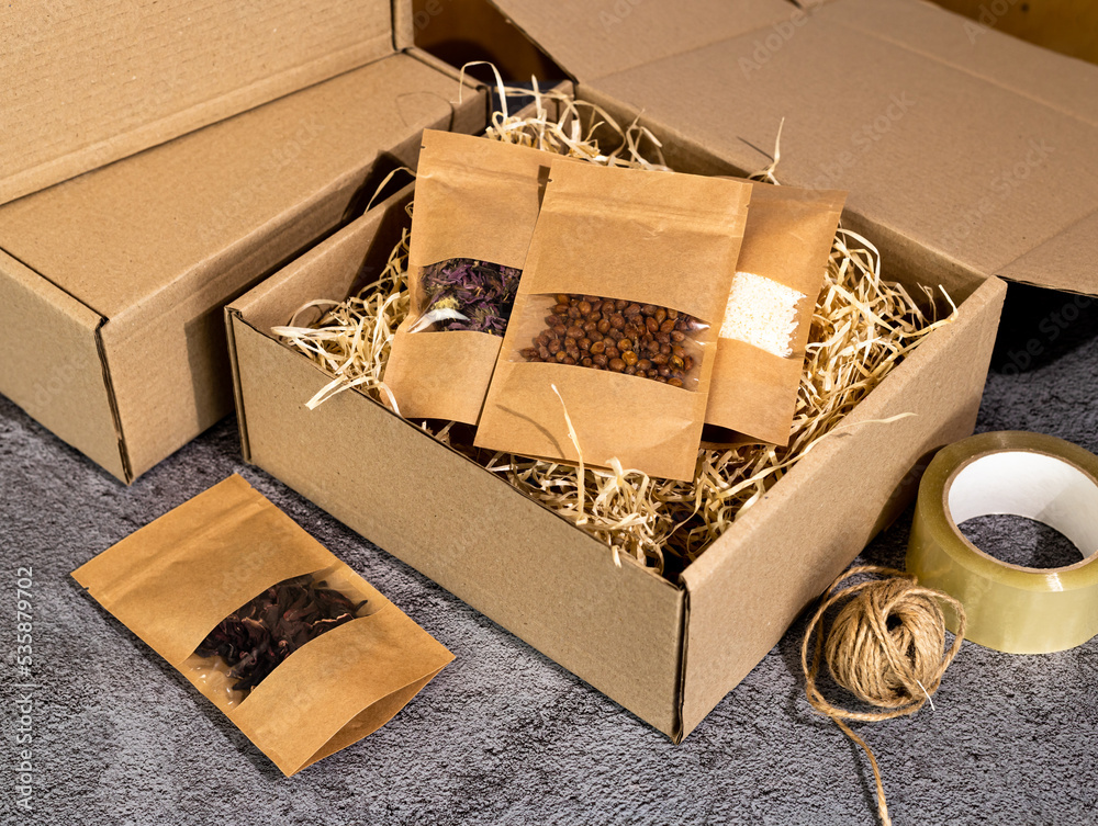 Brown kraft paper doypack bags with groceries on a cardboard box ...