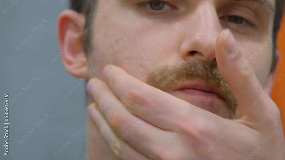 A man shaves his beard with an electric razor. The guy shaves off his ... A man shaves his beard with an electric razor. The guy shaves off his ...