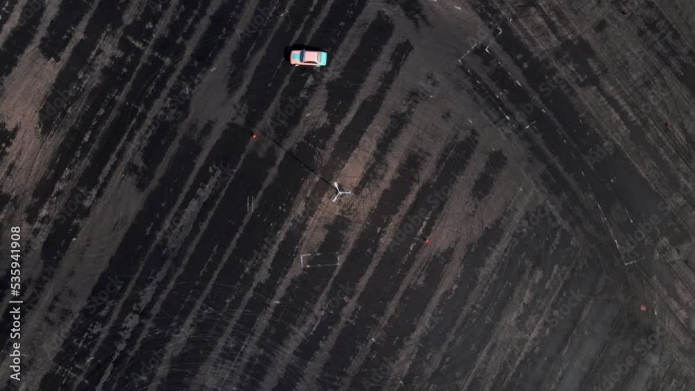 Drone top view of empty playground race space car turns at speed slides ...