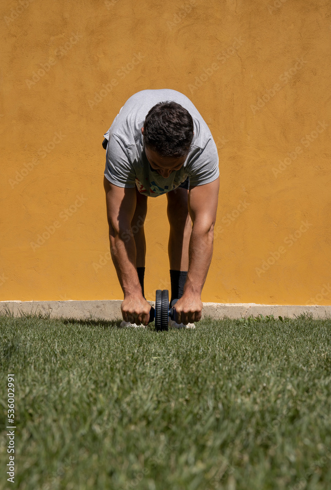 Young man working out lifting dumbbell outdoors during midday with ...